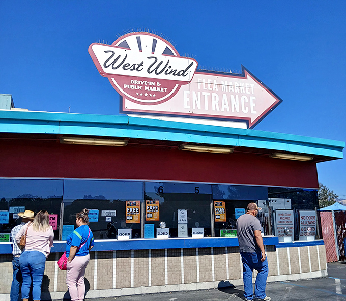 The retro-styled West Wind entrance sign points the way to twin treasures: movies under stars and daytime bargain hunting adventures.