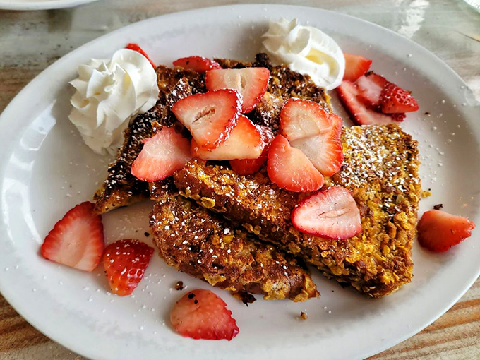 French toast that's having an identity crisis as dessert. Those strawberries aren't garnish &ndash; they're little red jewels of breakfast perfection.