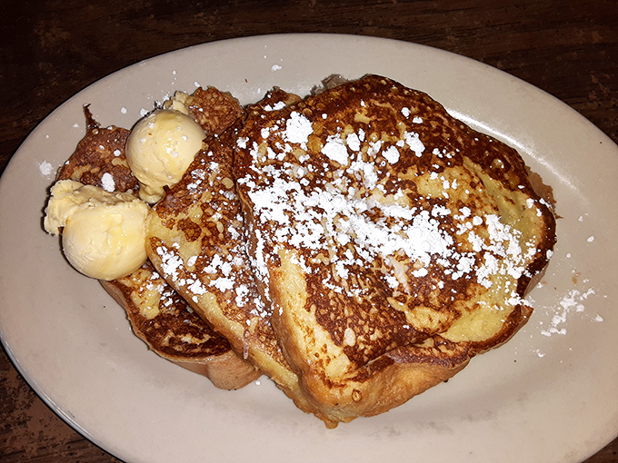 French toast that's achieved the perfect golden-brown exterior while maintaining that custardy interior—topped with butter and powdered sugar for good measure.