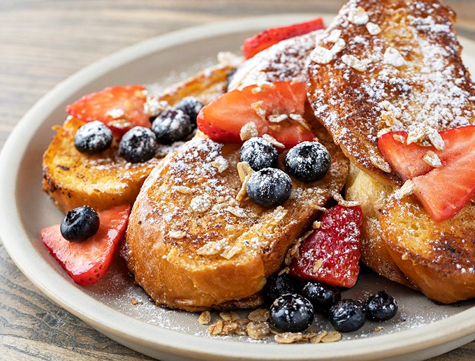 French toast that doesn't just say "good morning" but belts it out like Aretha Franklin. Those berries adding pops of color that belong in a museum, not just your stomach.