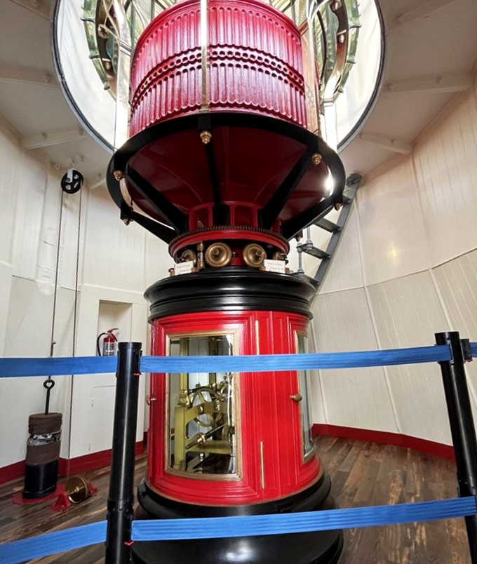 The crown jewel: This magnificent Fresnel lens once guided ships with its ruby glow, now retired but still commanding attention like a Broadway diva.