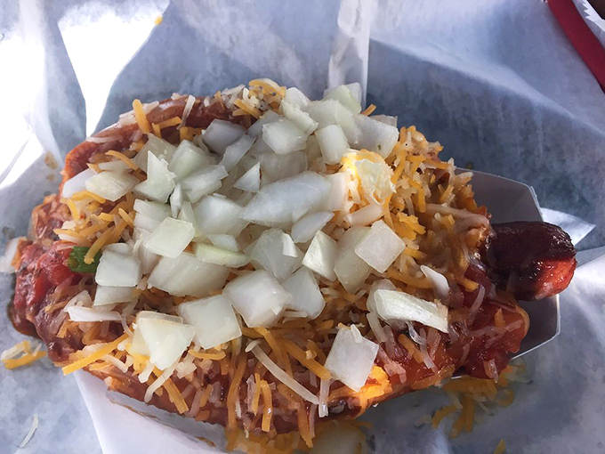This isn't just a hot dog&mdash;it's a flavor explosion topped with enough cheese and onions to make your cardiologist wince and your taste buds applaud.
