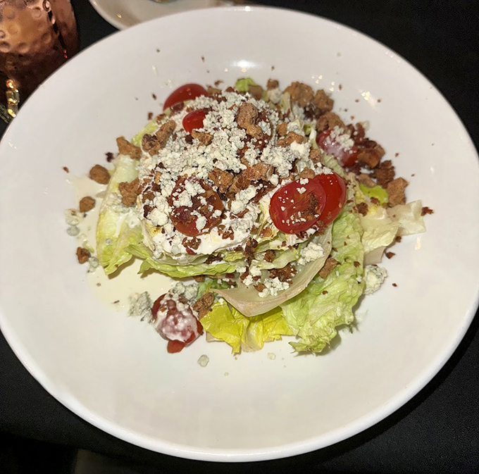 The wedge salad &ndash; that steakhouse classic &ndash; gets the Bare Bones treatment with fresh tomatoes, blue cheese crumbles, and bacon bits that refuse to be mere garnish.