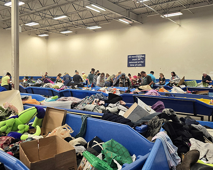 The organized chaos of bargain paradise. Notice the sign politely asking shoppers to stay clear during bin rotations—the thrifter's equivalent of "Dinner is served!"
