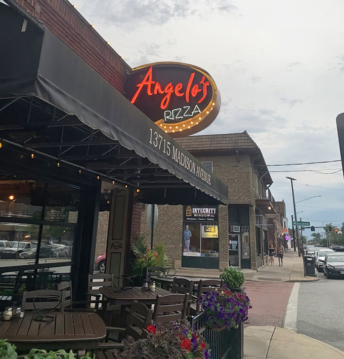 The neon glow of Angelo's sign against the evening sky—like a lighthouse guiding hungry travelers to their delicious destination.