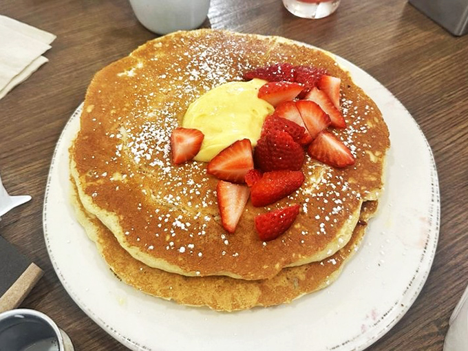 Golden pancakes adorned with fresh strawberries and a dollop of sunshine &ndash; proof that mornings can actually be something to celebrate.