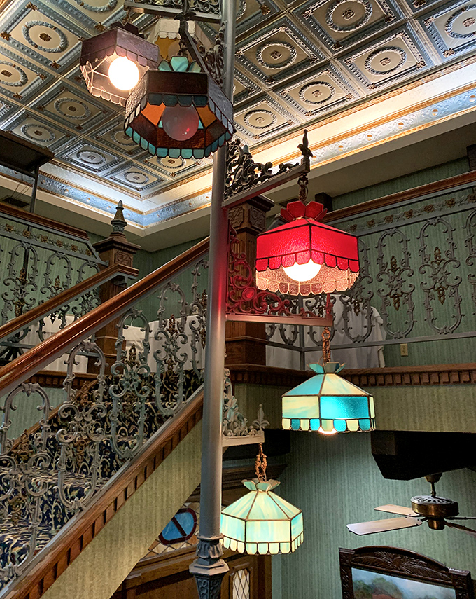 Colorful stained glass lamps cast a warm glow over the staircase, creating the perfect ambiance for your journey into supper club nirvana.