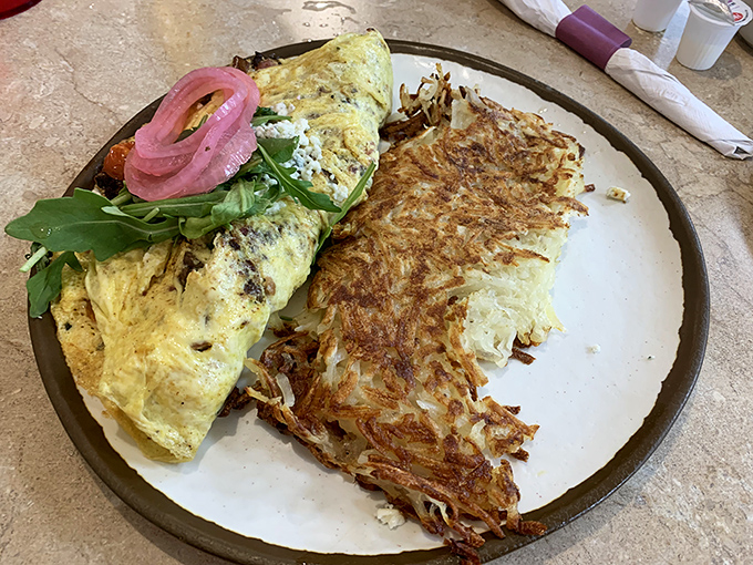 An omelet that's had a proper education, graduating with honors in flavor, paired with hashbrowns crispy enough to make a potato proud.
