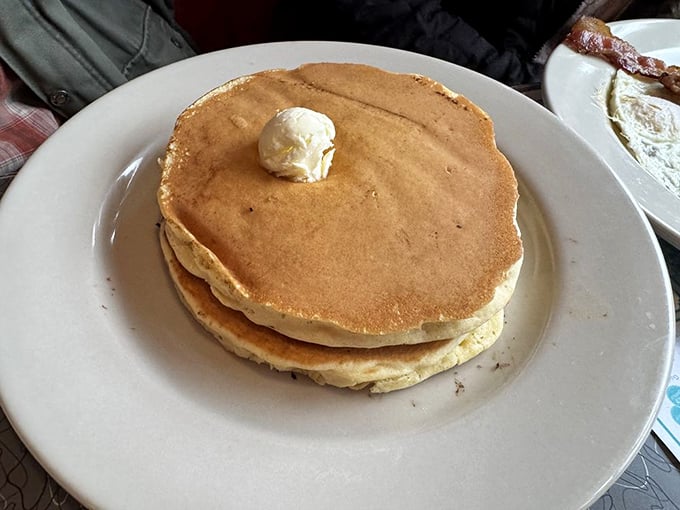 Pancakes so perfectly golden they deserve their own Instagram account. That melting butter pat on top is performing a slow, delicious swan dive.