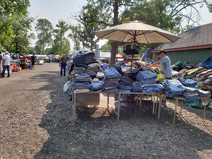 Denim mountain! More jeans than a 1990s high school reunion, stacked with military precision under the watchful eye of Michigan's summer sky.