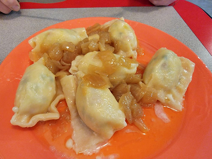 These pierogies glisten with buttery goodness, topped with caramelized onions that transform simple dumplings into objects of desire.