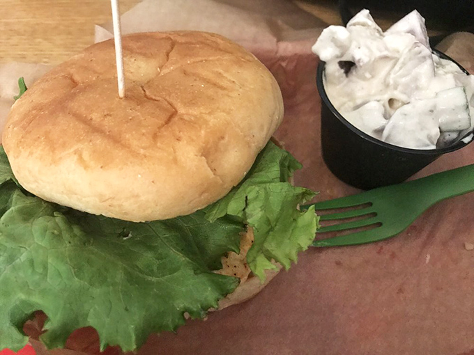 A sandwich that demands both hands and your full attention. Fresh lettuce peeks out like it's trying to escape, but trust me&mdash;you'll want every component in each bite.