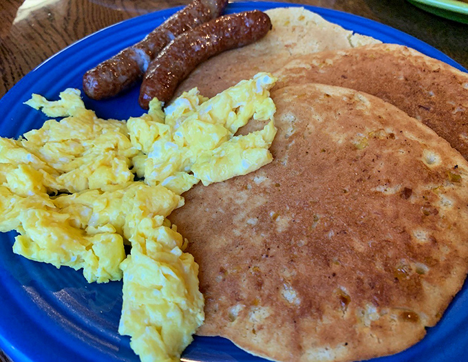 Breakfast perfection on a lime green plate. That sunny-side-up egg crowning a mountain of gravy-covered goodness is practically winking at you.