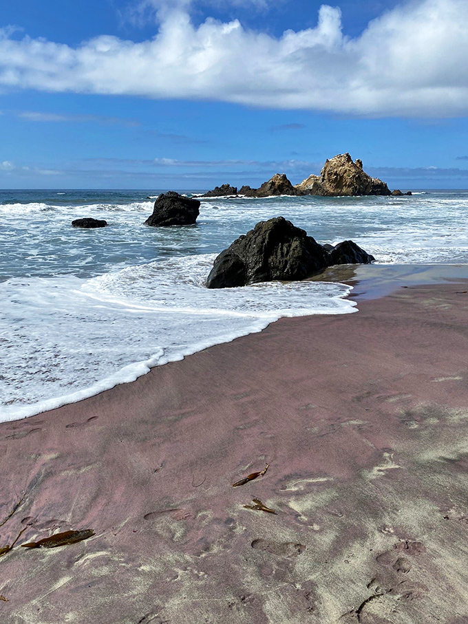 Mother Nature's artistic flourish: the beach's famous purple-hued sand creates an otherworldly canvas where waves paint temporary masterpieces.