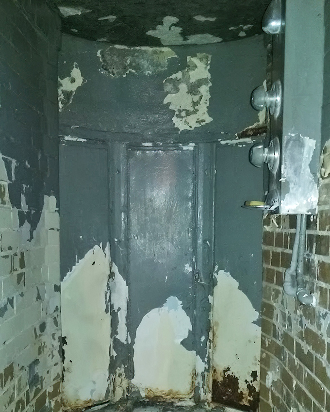 The ultimate punishment: solitary confinement in this deteriorating cell where peeling paint and crumbling walls mirror the psychological decay that isolation could bring.