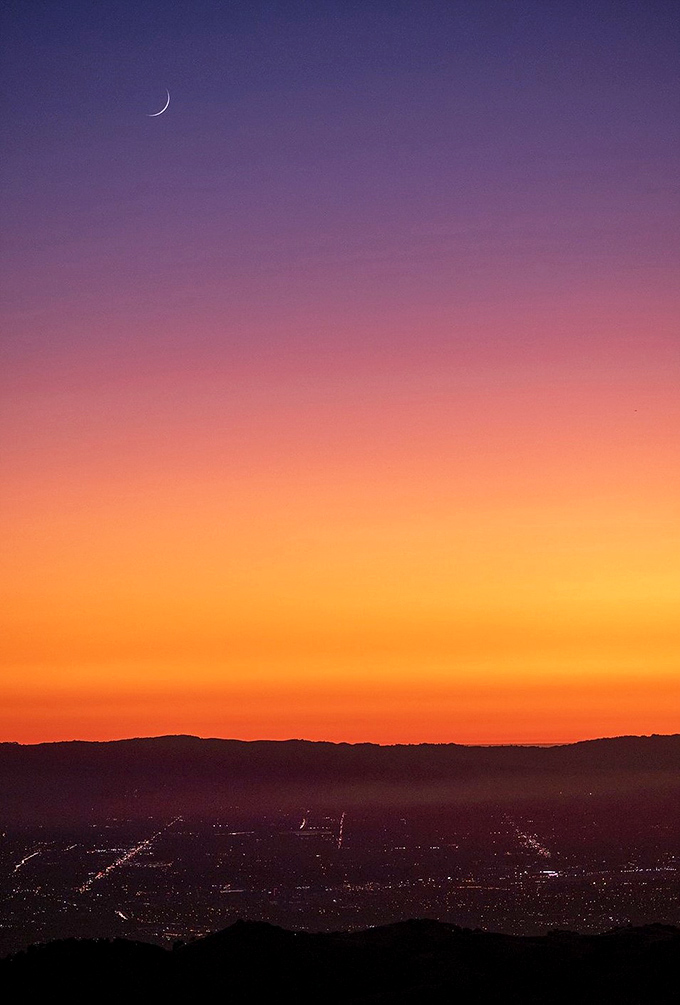 Nature's own light show outshines any Vegas spectacle. This sunset gradient from purple to orange makes even the most jaded traveler pause in wonder.