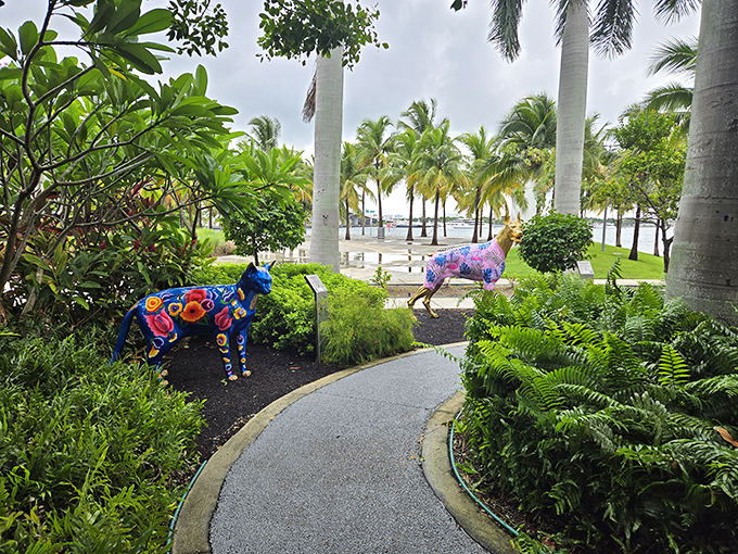 Two colorful canines stand guard along the winding path. The blue and multi-colored sculptures pop against Miami's lush tropical landscaping.