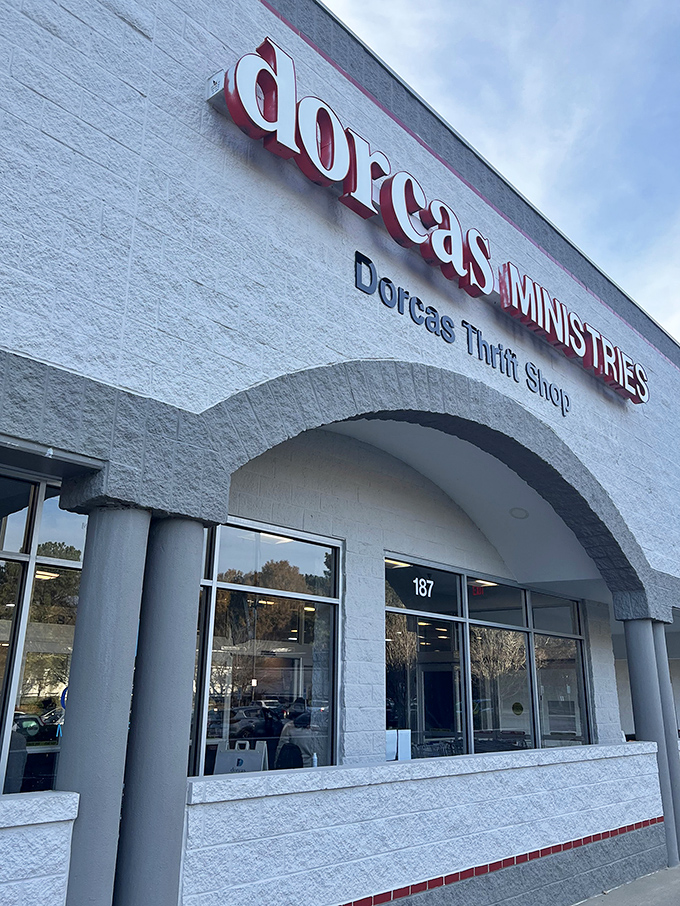 The elegant arched entrance of Dorcas Ministries Thrift Shop in Cary features bold red lettering against crisp white walls. Upscale thrifting at its finest!