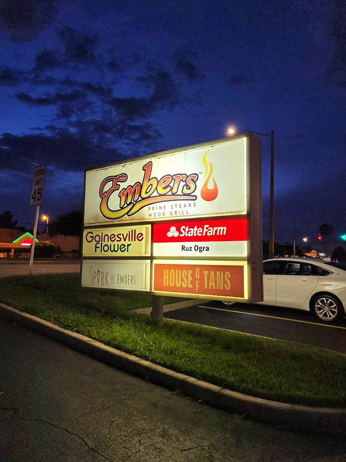 Embers' illuminated sign glows like a beacon for hungry Gainesville carnivores seeking wood-fired perfection.