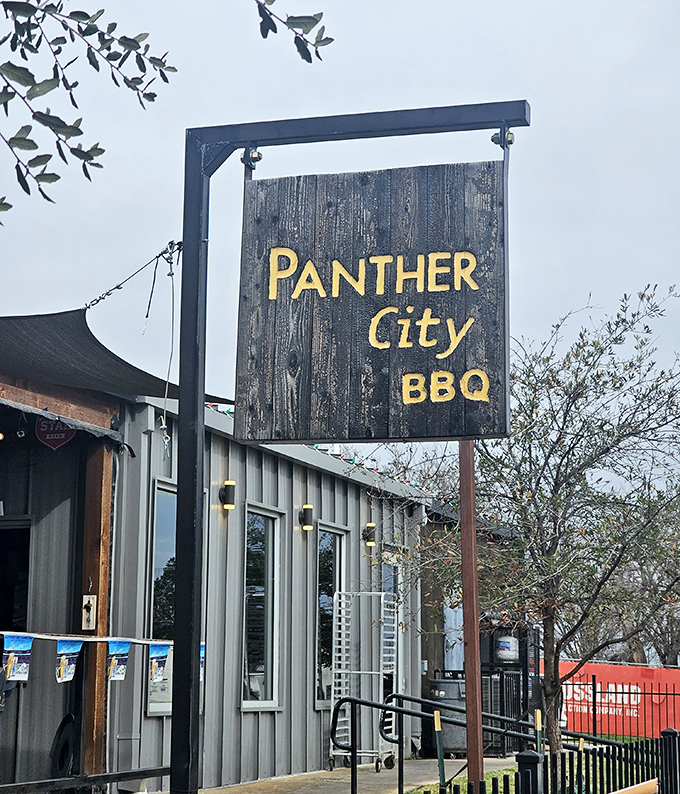 Panther City's rustic wooden sign swings like an old saloon, inviting modern cowboys to barbecue paradise.