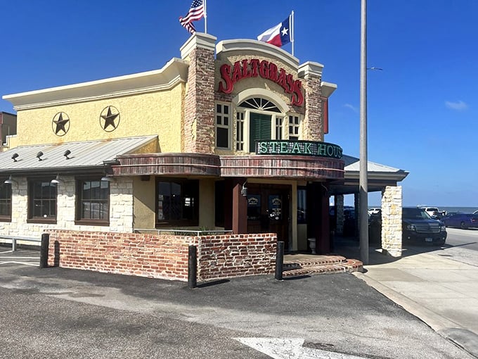 Saltgrass stands proud with its distinctive yellow walls and brick accents. The flags flutter in the Gulf breeze like a welcome sign.