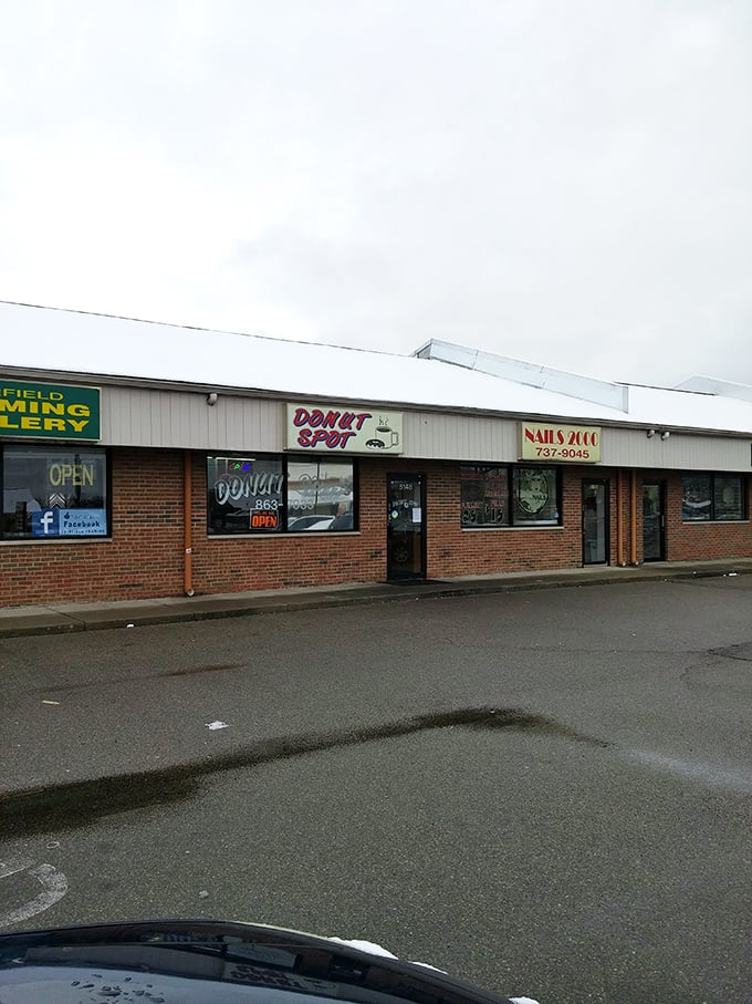 Strip mall locations often hide the greatest culinary gems - this colorful sign marks genuine donut treasure.