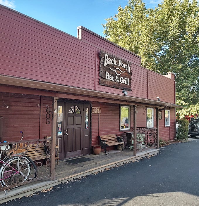 The rustic porch setting creates the perfect backdrop for barbecue that tastes like genuine Southern hospitality served daily.