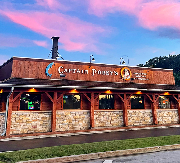 As twilight falls, Captain Porky's wooden facade glows with promise &ndash; seafood dreams in a log cabin setting.