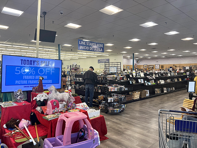 Look at that 50% off sign glowing like a beacon of hope! Inside Dorcas Thrift Shop, toys, books, and treasures await while shoppers browse neatly organized aisles.