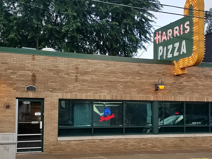 That retro sign has watched Rock Island change while the pizza inside stayed gloriously, stubbornly the same.