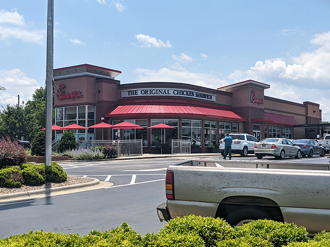 The welcoming Chick-fil-A restaurant invites visitors with its bright red umbrellas and friendly service, perfect for a casual meal or quick stop.