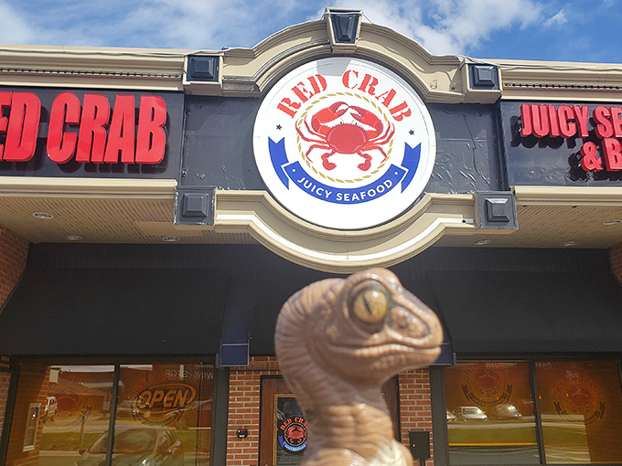 The bold crab logo stands guard over seafood treasures within. That dinosaur seems equally excited about the spicy seafood boils inside!