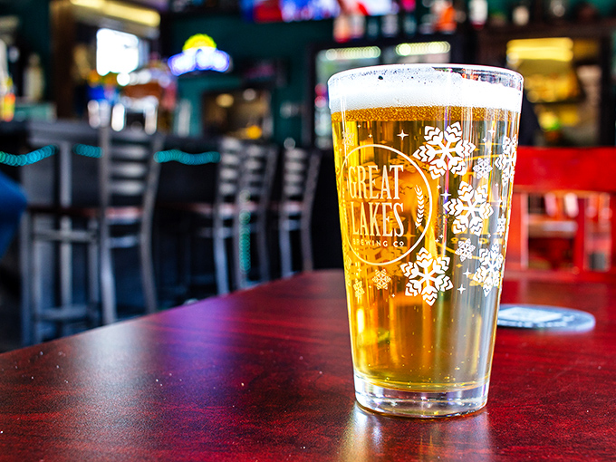 A perfectly poured pint of Great Lakes beer waits patiently for its companion sandwich, golden and inviting like liquid sunshine.