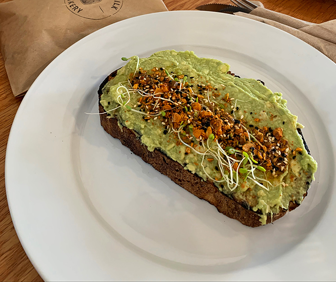 Avocado toast elevated beyond millennial meme status with sprouts, seeds, and Egyptian dukkah bringing sophisticated complexity.