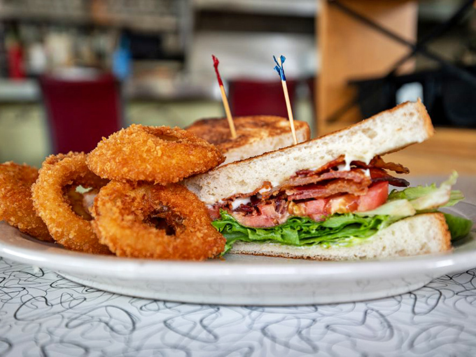 The humble BLT, elevated to art form. Crispy onion rings on the side create the perfect textural counterpoint to this sandwich classic.