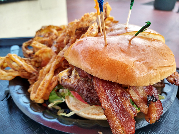 A bacon cheeseburger with a fortress of onion rings standing guard. Your diet plan just called—it's taking the day off.