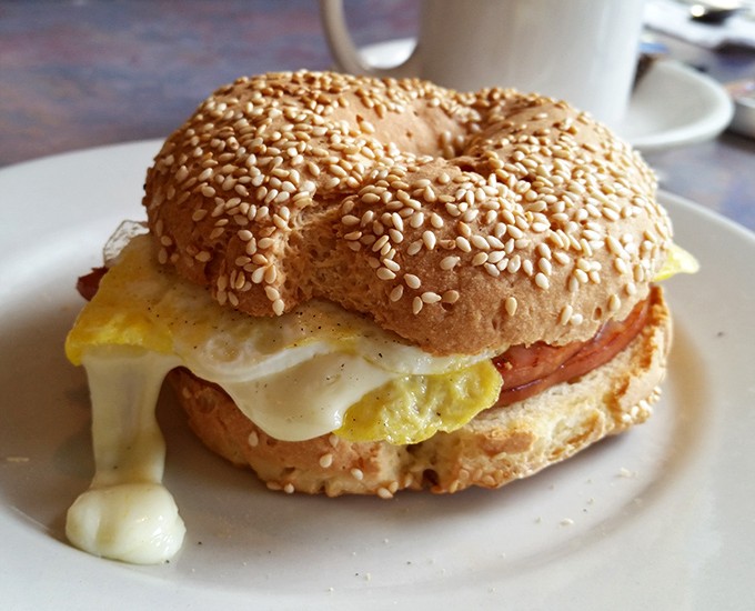 Breakfast sandwich architecture at its finest &ndash; the sesame bagel foundation supporting that glorious egg-cheese-meat trifecta.