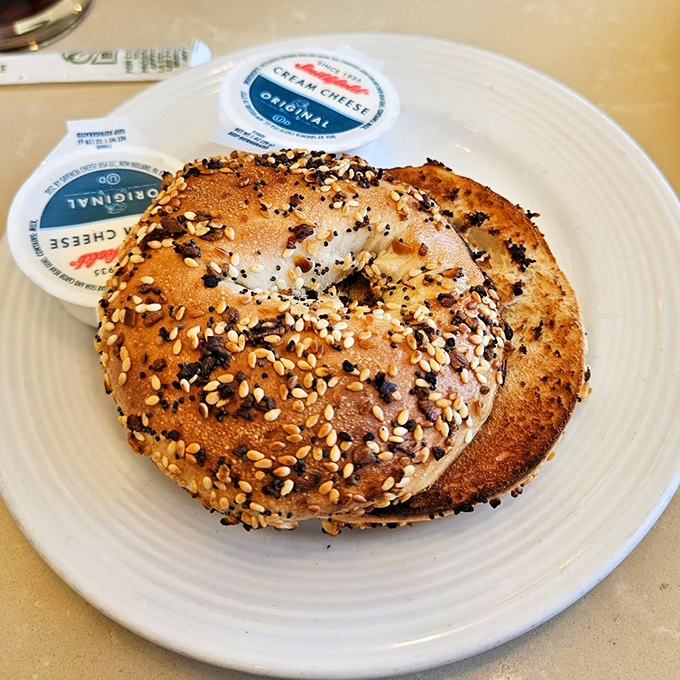 This isn't just any bagel&mdash;it's a canvas of seeds and grains, waiting patiently beside cream cheese for your breakfast masterpiece to begin.