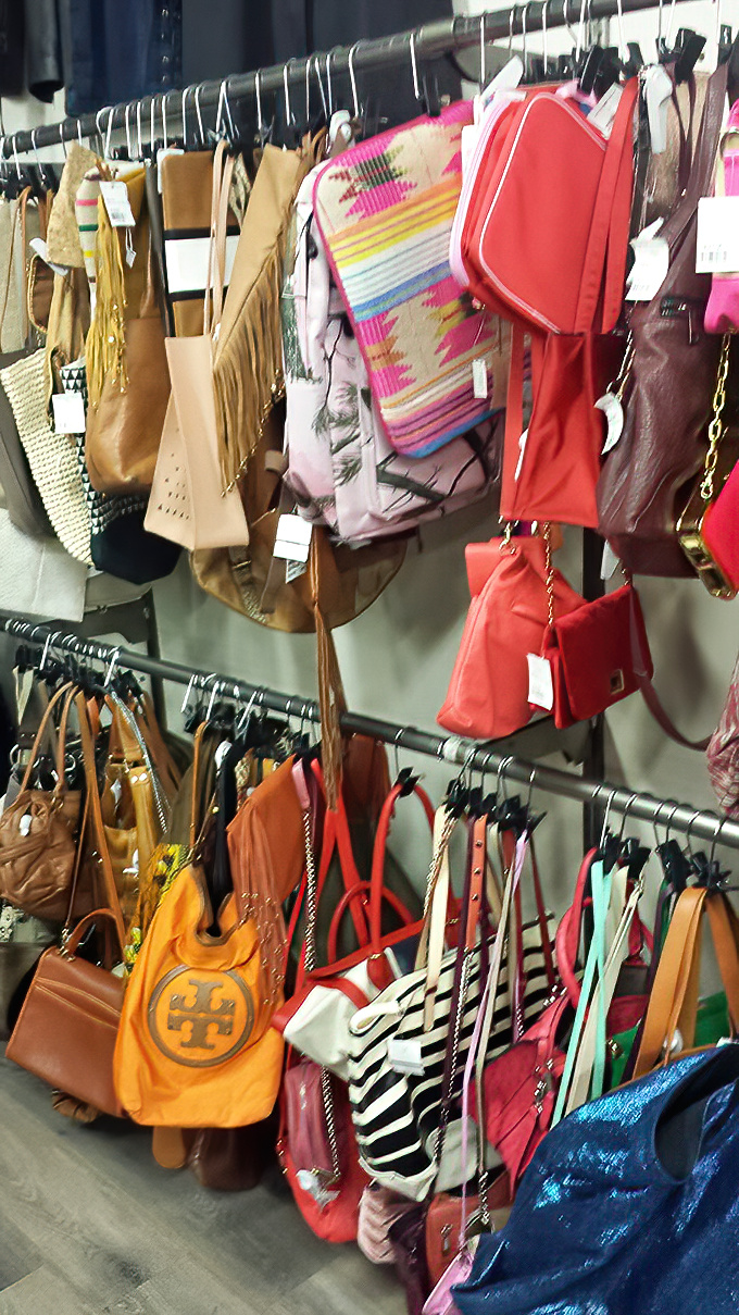 Handbag heaven! From practical totes to statement clutches, these pre-loved purses hang like colorful fruit ready to be plucked from the fashion tree.