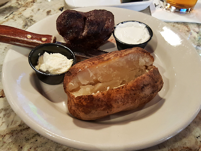Not just any baked potato—this is the Cadillac of spuds, split open to reveal its fluffy interior, ready for a dollop of sour cream.