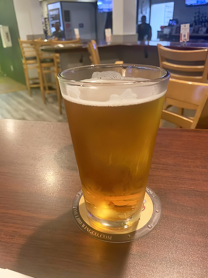 A cold beer in a proper glass&mdash;civilization's perfect answer to barbecue's primal appeal. The wood tables say "stay awhile."