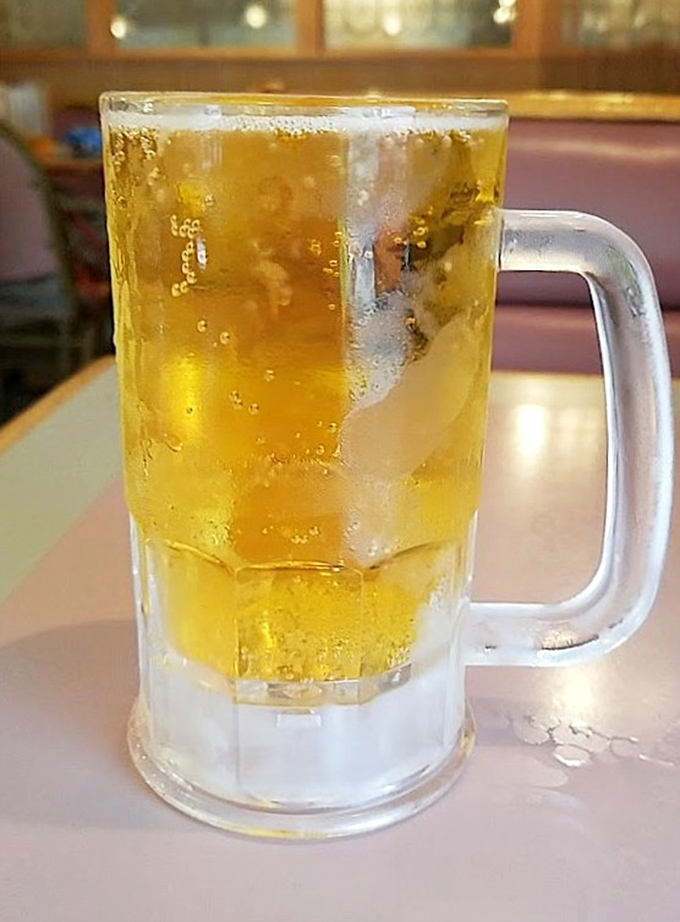 A frosty mug of beer so cold it's sweating almost as much as you will be when deciding between one more slice or calling it quits.