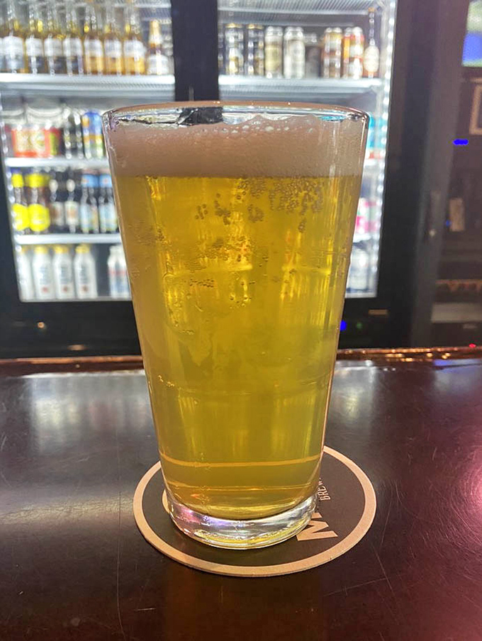 A perfectly poured beer catching the light, condensation beading on the glass. The ideal companion for those gravy fries and the game.