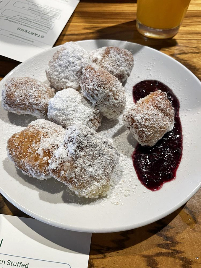 These powdered sugar-dusted beignets with berry compote aren't just pastries; they're little pillows of joy that New Orleans would approve of.