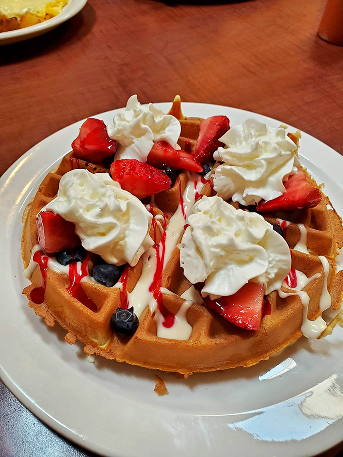 A Belgian waffle that deserves its own Instagram account. Those berries and whipped cream aren't just toppings&mdash;they're the supporting cast in a breakfast blockbuster.