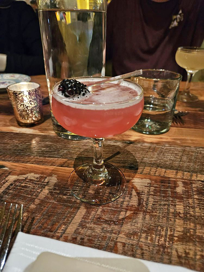 This cocktail glows like a sunset in a glass, topped with a blackberry that's basically saying, "You're welcome for the Instagram moment." 