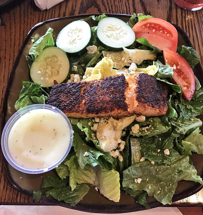 Blackened salmon crowns fresh greens in a salad that proves healthy eating doesn't mean sacrificing bold flavors.