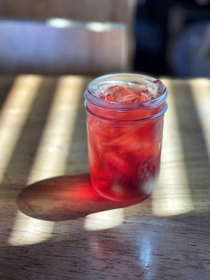 That ruby-red refreshment catching the sunlight isn't just a drink&mdash;it's the perfect palate cleanser between bites of oceanic bliss.