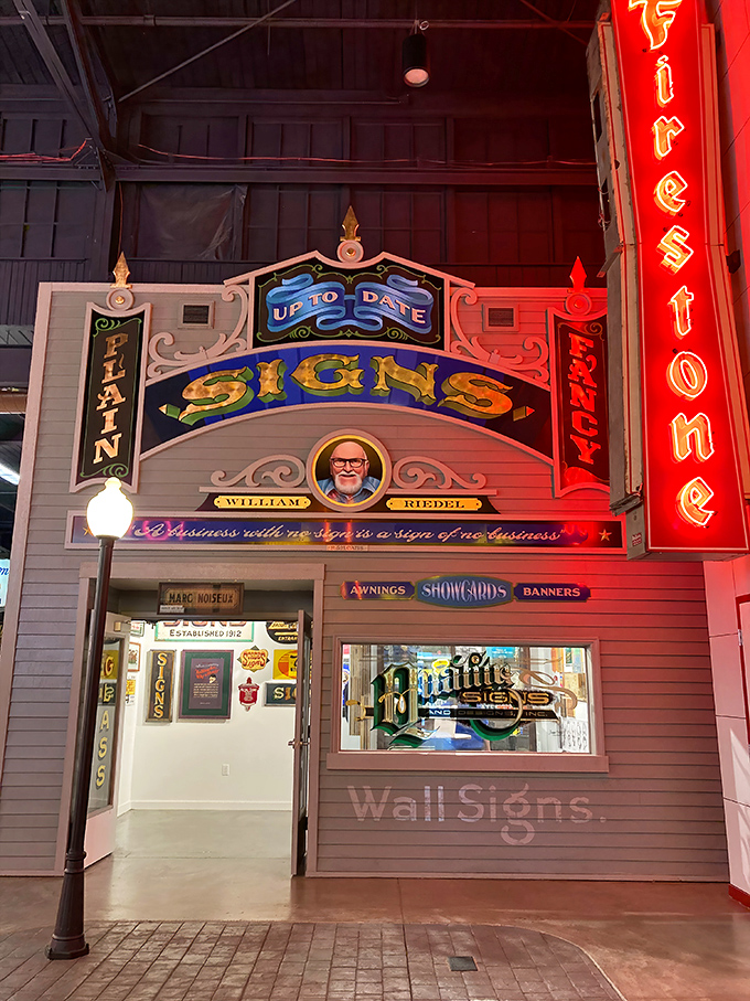 The "UP-TO-DATE SIGNS" storefront recreates the craftsmanship era when sign-making was both commerce and art form.