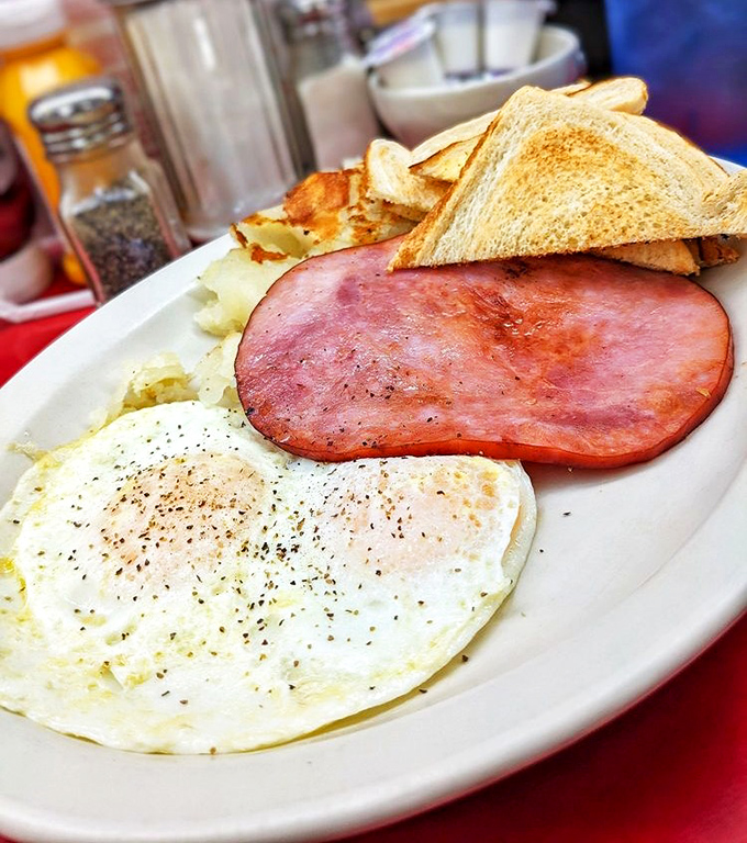 The breakfast trinity: perfectly toasted bread, eggs with just-right yolks, and hash browns that crackle with each forkful. Simple pleasures at their finest.